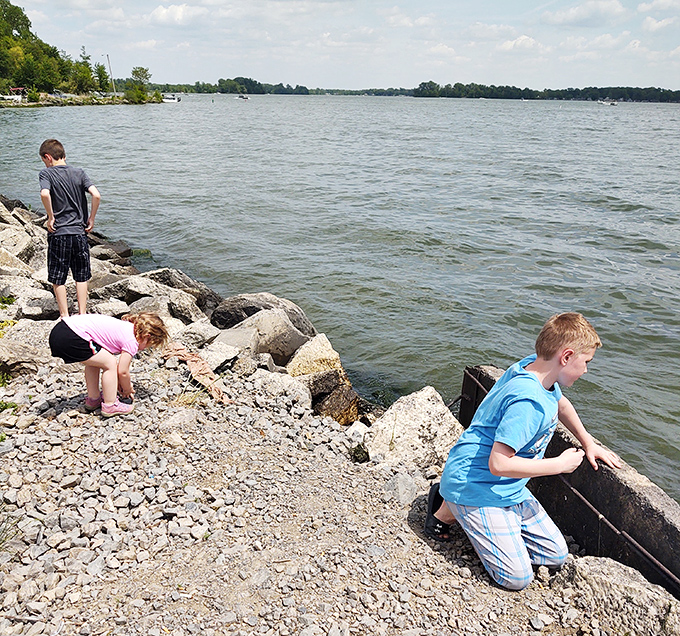 Young explorers conducting serious geological research (or just hunting for cool rocks) along Indian Lake's shoreline &ndash; childhood curiosity in its natural habitat.