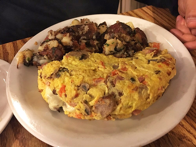 This isn't just any omelet&mdash;it's a fluffy golden canvas where vegetables and protein unite in perfect harmony. The crispy potatoes deserve their own fan club.