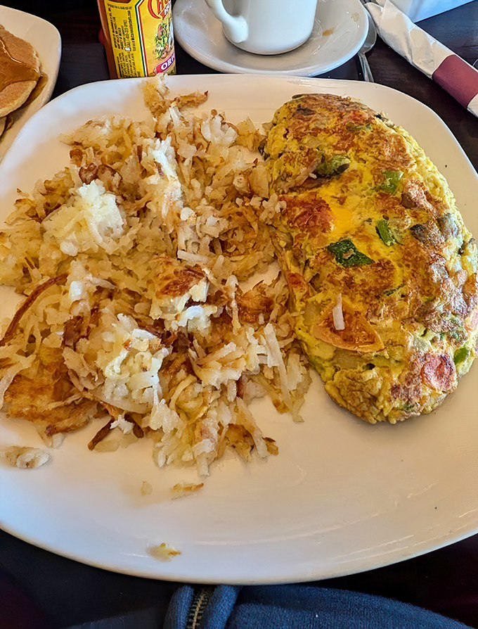 This isn't just an omelet&mdash;it's an edible work of art with perfectly crisped hash browns that deserve their own fan club.