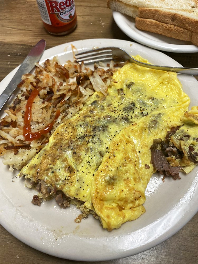 Behold the star of the show: a perfectly executed omelet alongside crispy home fries that would make your grandmother both proud and jealous.