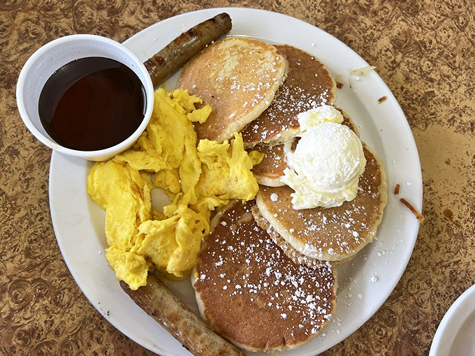 Pancake perfection meets scrambled sunshine on a plate. That powdered sugar dusting isn't just garnish&mdash;it's breakfast pixie dust.