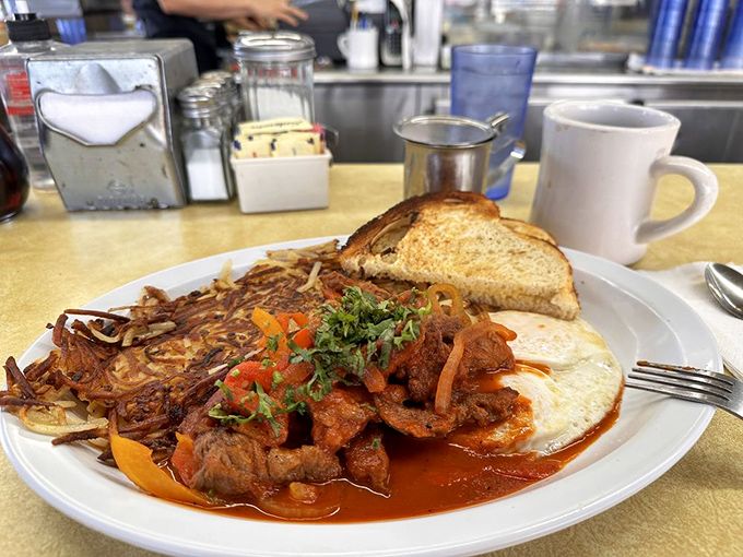 This isn't just steak and eggs; it's a morning symphony where spicy picadillo, perfectly runny eggs, and crispy potatoes perform in delicious harmony.