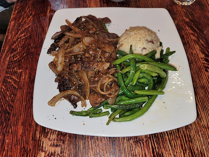 Tender beef swimming in rich gravy with perfectly sautéed onions. This isn't just pot roast; it's edible nostalgia on a plate.