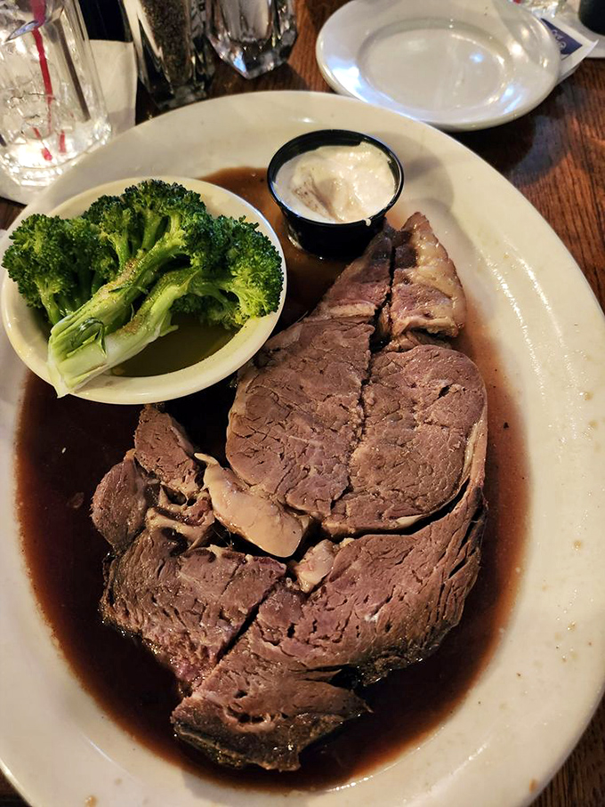 The prime rib arrives like royalty—a tender, juicy masterpiece swimming in savory au jus. That perfect pink center isn't just cooked, it's engineered for maximum flavor satisfaction.