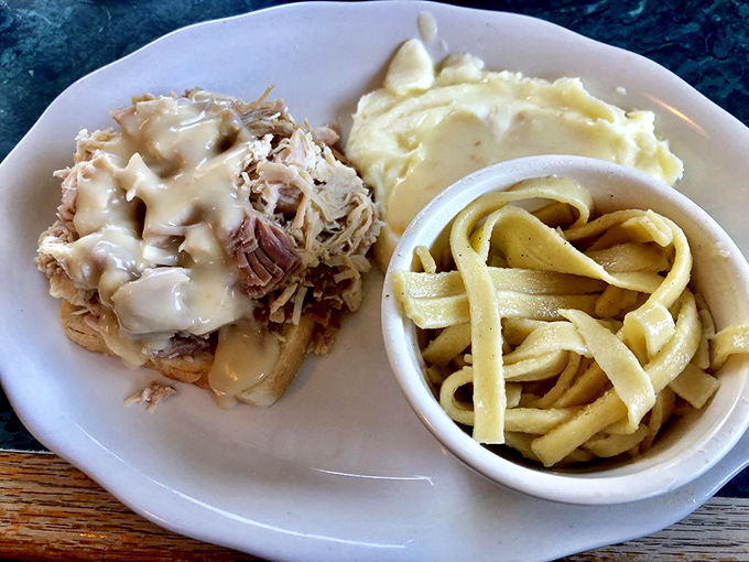 This isn't just pulled pork—it's a tender masterpiece crowned with melty cheese, served alongside noodles that would make any grandmother nod in approval.