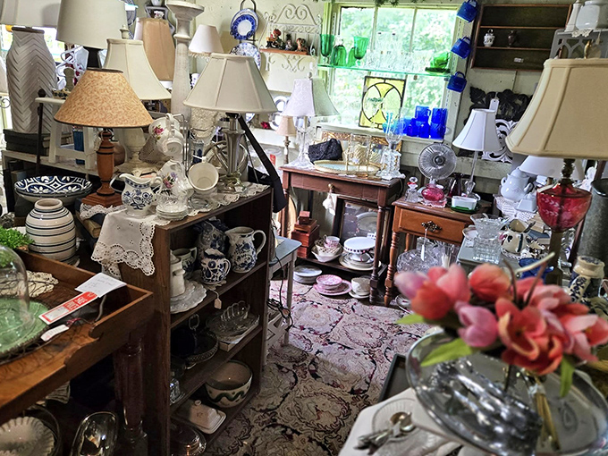 A collector's dream corner where Depression glass catches the light, vintage lamps stand at attention, and porcelain figurines wait patiently for new homes.
