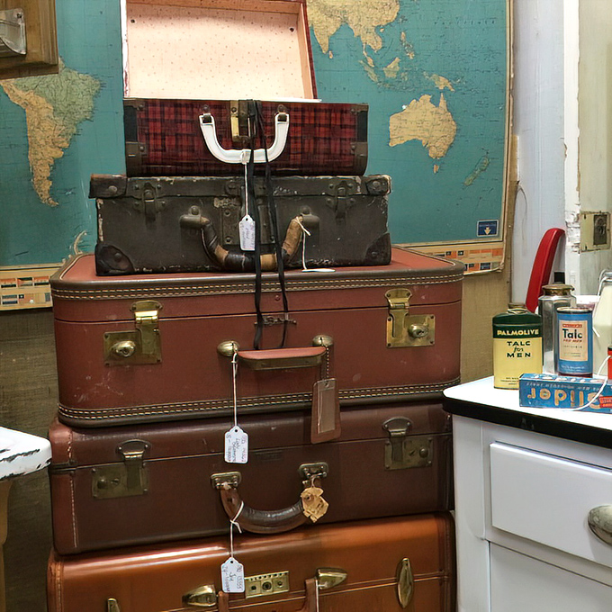 Stacked like a time traveler's luggage collection. These vintage suitcases against a world map backdrop remind us when travel was an elegant affair rather than a barefoot TSA shuffle.