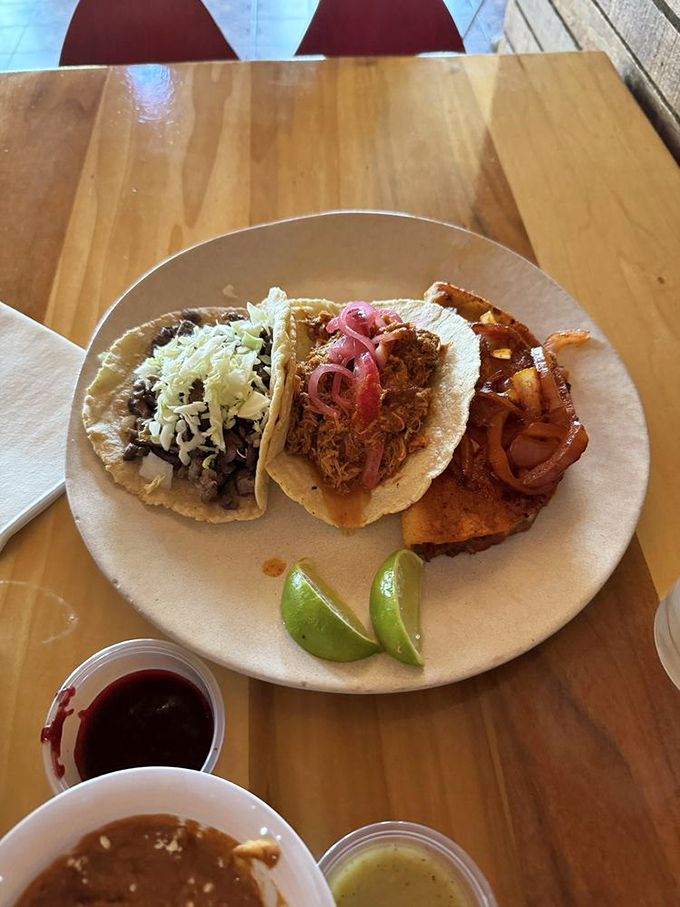 Taco trinity perfection: Each handmade tortilla cradles its filling like a precious gift, with lime wedges standing by for that essential citrus punch.