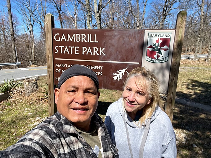 Happy explorers marking their adventure at the park entrance sign. That feeling when you've found your new favorite weekend escape!