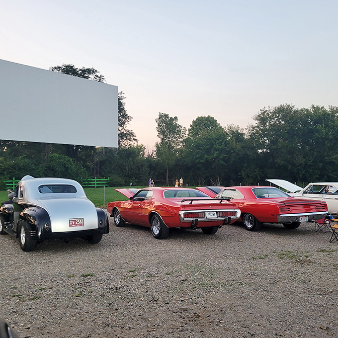 Classic cars line up for showtime, their gleaming chrome reflecting an era when drive-ins were date night central. 