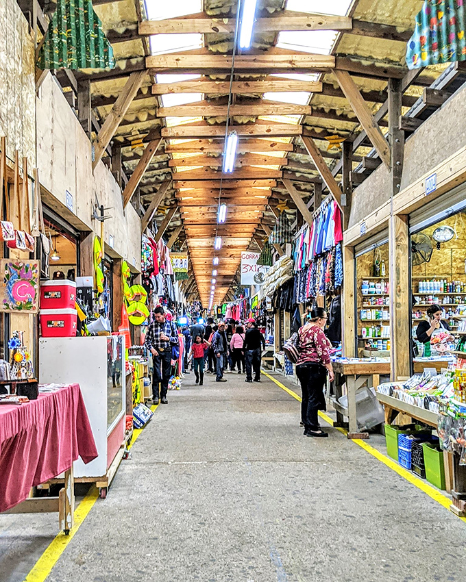 The golden morning light bathes rows of market tents where early birds catch the best bargains before the crowds arrive.