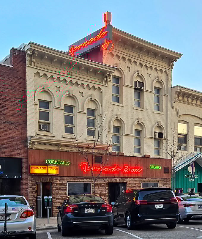 The Tornado Room's vintage neon sign glows like a lighthouse for hungry souls navigating the sea of mediocre dining options.
