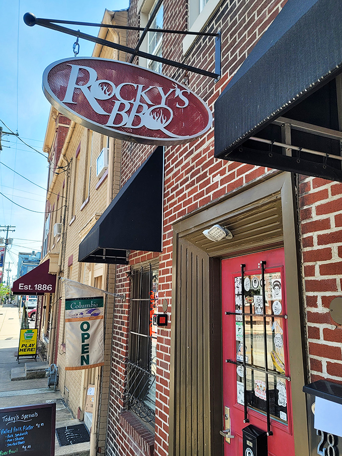 Rocky's hanging sign promises BBQ salvation on a brick-lined street. Small door, big flavors waiting inside!