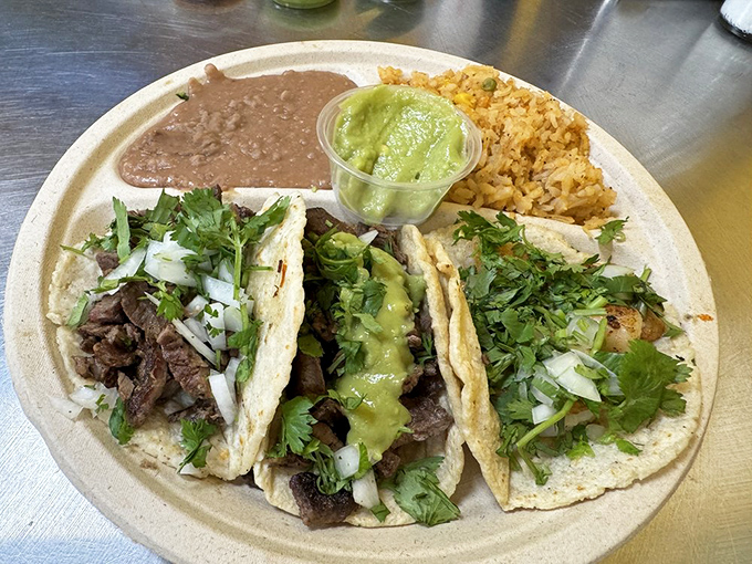 The holy trinity of street tacos &ndash; perfectly seasoned meat, fresh cilantro, and onions on handmade tortillas with a side of Mexican rice and beans.