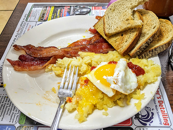 The breakfast trinity: perfectly cooked eggs, crispy bacon, and hash browns that crackle with each forkful. Toast stands by for yolk-sopping duty.