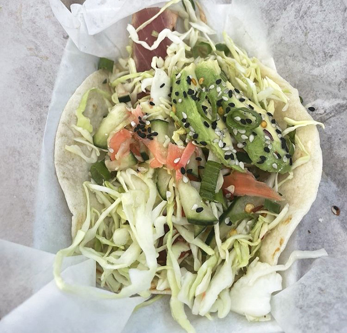 The ahi taco, adorned with sesame seeds like tiny jewels, offers a perfect marriage of ocean freshness and Asian-inspired flavors.
