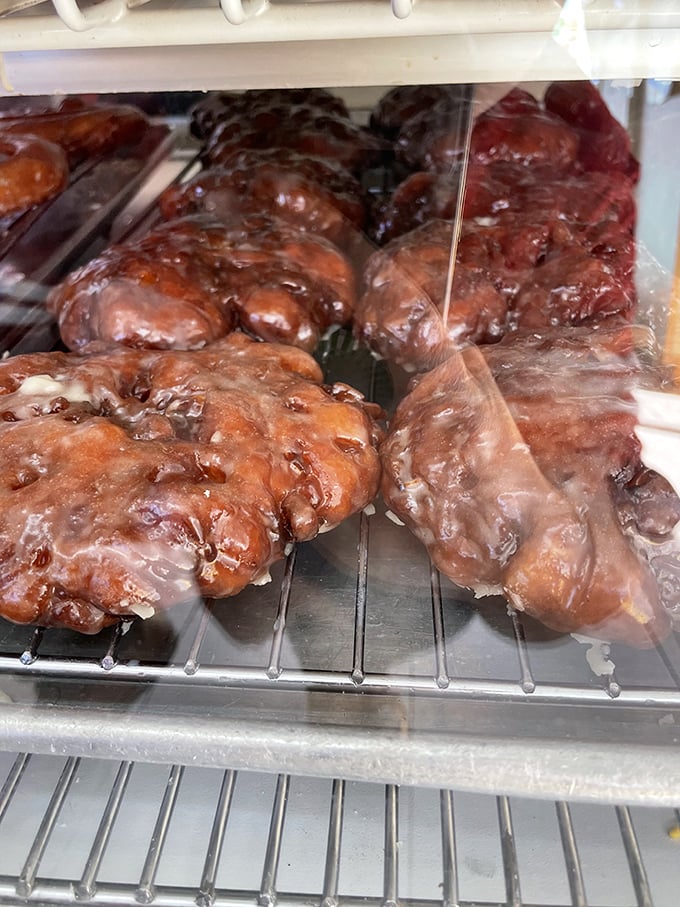 Apple fritters that glisten with glaze, ready to shatter into a thousand delicious apple-studded pieces with each heavenly bite.