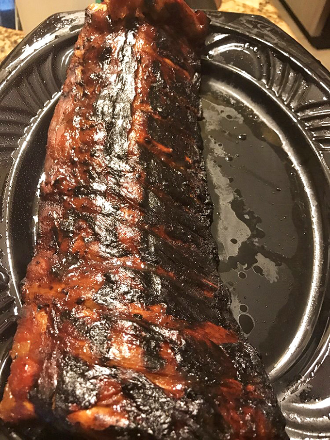 Behold the holy grail of barbecue &ndash; ribs with that perfect mahogany bark, glistening with sauce and promising a flavor experience worth every napkin you'll need.