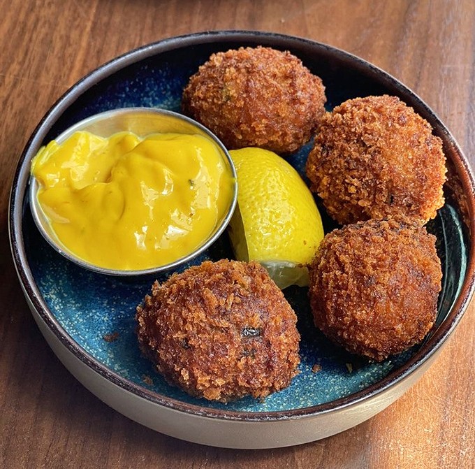 These bacalao croquettes aren't just fried—they're transformative little spheres of joy with a golden crust that audibly sings when you bite in.