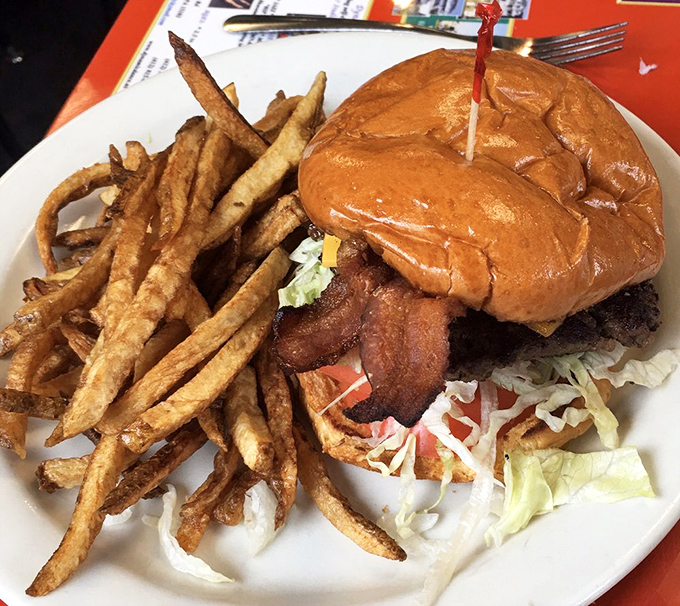 This isn't just a burger&mdash;it's architecture. Golden fries standing tall beside a bacon cheeseburger that requires both hands and a strategy.
