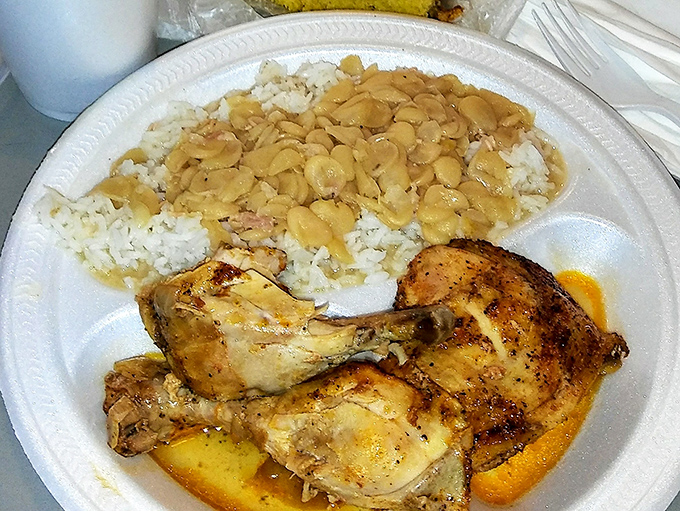 Baked chicken swimming in its own savory juices, with lima beans over rice—proof that heaven exists and it's served on a styrofoam plate.