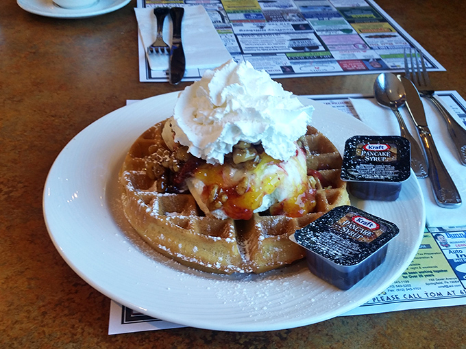 This Belgian waffle isn't just breakfast, it's architecture—a golden foundation topped with a melting scoop of ice cream and whipped cream.