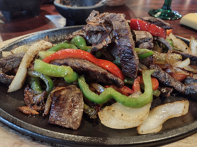 Sizzling steak fajitas with the perfect char, where every bite delivers that magical combination of caramelized meat and crisp vegetables. Dinner and a show!