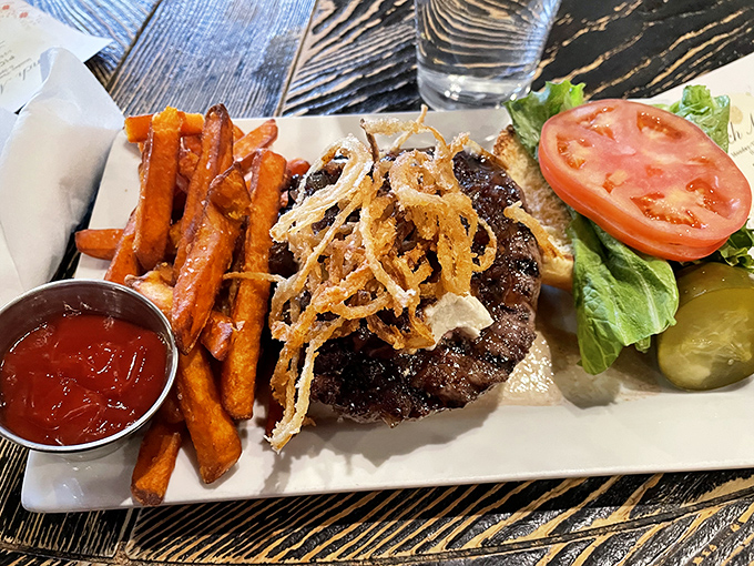 A burger should make you forget your table manners, and this towering bison creation with crispy onions and sweet potato fries practically demands it.