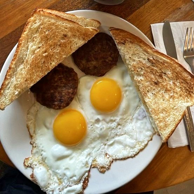 Sunny-side up eggs with perfectly browned sausage patties and toast&mdash;a breakfast plate that says "good morning" better than any rooster ever could.