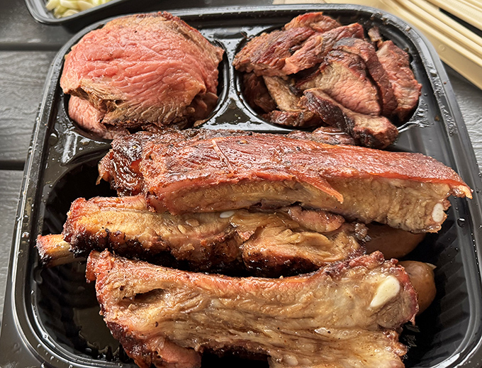 Behold the holy trinity of barbecue—tri-tip, ribs, and what appears to be pulled pork—a smoky sermon that converts even the most devout health nuts.