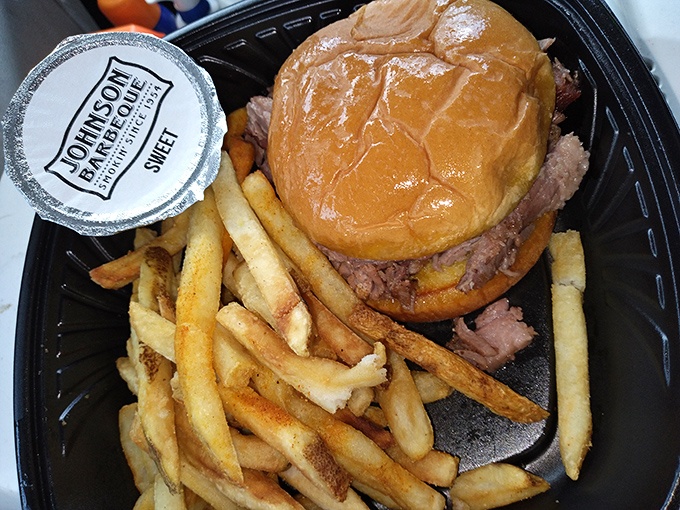 The sandwich arrives with fries standing at attention, as if they know they're escorting barbecue royalty to your eager taste buds.