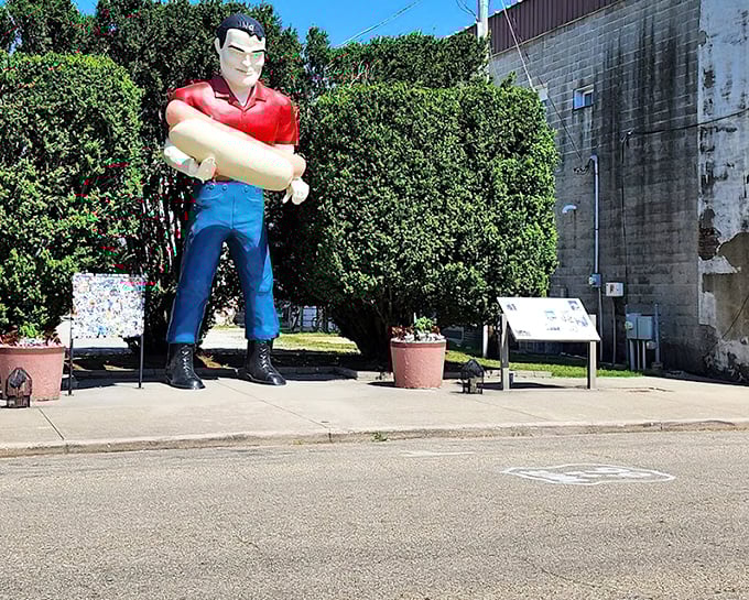 This red-shirted colossus once beckoned hungry drivers from miles away. Now he stands as a silent sentinel of small-town America, arms eternally folded in fiberglass confidence.