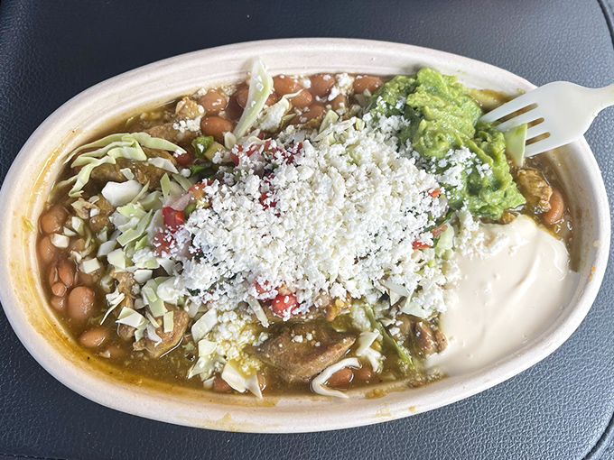 This isn't just a burrito bowl; it's an edible color palette where guacamole, cheese, beans, and meat create a symphony of flavors worth driving for.