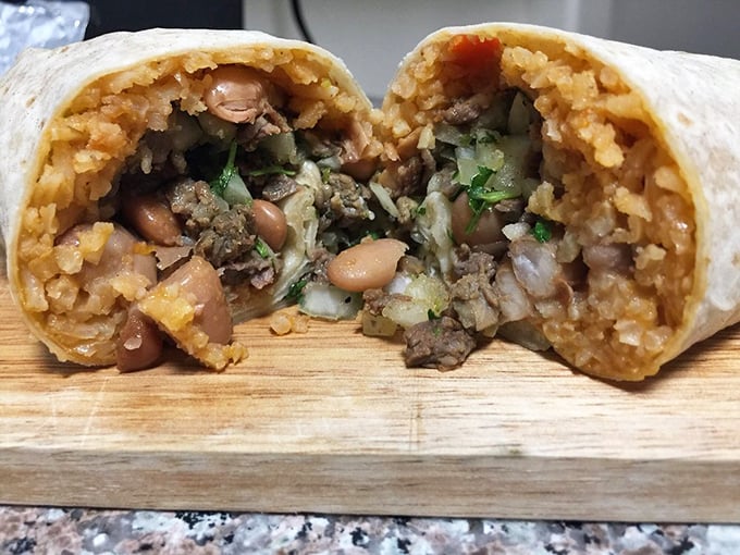 Cut into this burrito and witness the perfect cross-section of culinary joy&mdash;beans, rice, and perfectly seasoned meat creating a harmony of flavors.