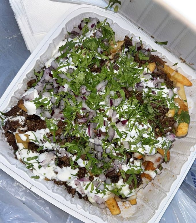 Golden fries buried under tender carne asada, creating the ultimate comfort food fusion that dreams are made of. 