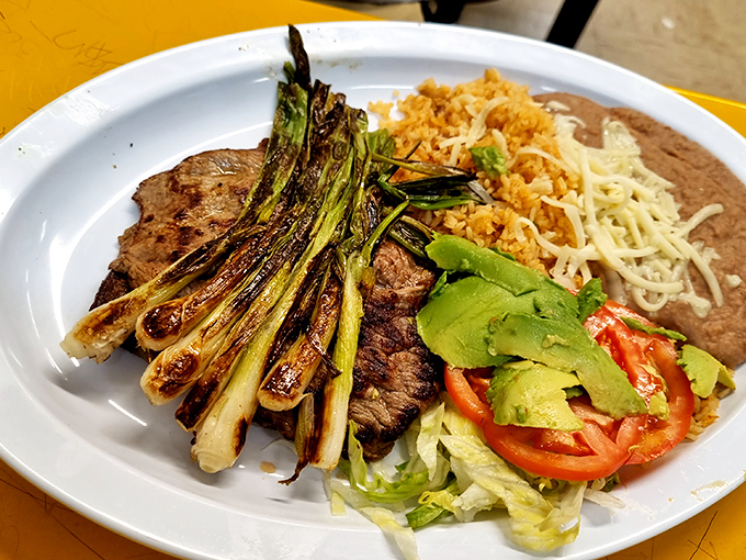 This isn't just carne asada &ndash; it's a plate of grilled steak nirvana with all the fixings, including those perfectly charred green onions that deserve their own fan club.