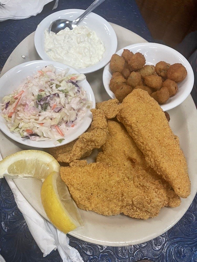 The cornmeal-crusted catfish arrives golden and crispy, with coleslaw and hushpuppies standing by as worthy supporting characters.