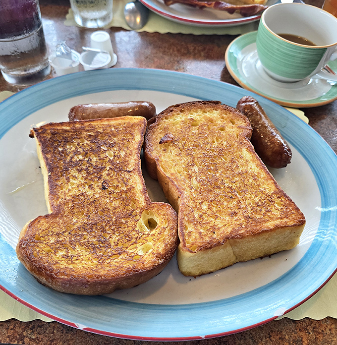 Golden challah French toast that's achieved that mythical balance: crispy edges, custardy center, and enough butter to make your cardiologist wince approvingly.