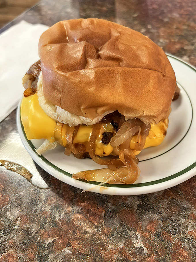 A proper diner cheeseburger with grilled onions that doesn't need Instagram filters to look good. The kind of sandwich that makes fast food chains weep with inadequacy.
