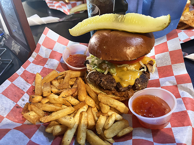 Meet burger perfection: a juicy patty, melted cheese, fresh toppings, and that pickle spear standing tall like a flag claiming delicious territory.