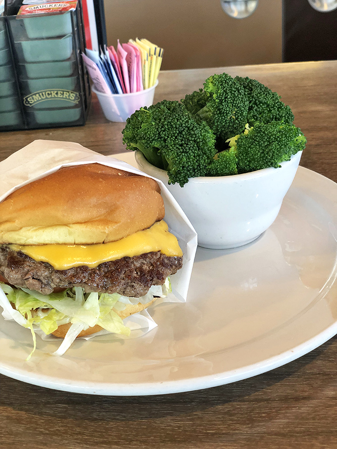 Behold the cheeseburger in its natural habitat&mdash;perfectly melted American cheese on a hand-formed patty. That broccoli is fooling nobody about your intentions.