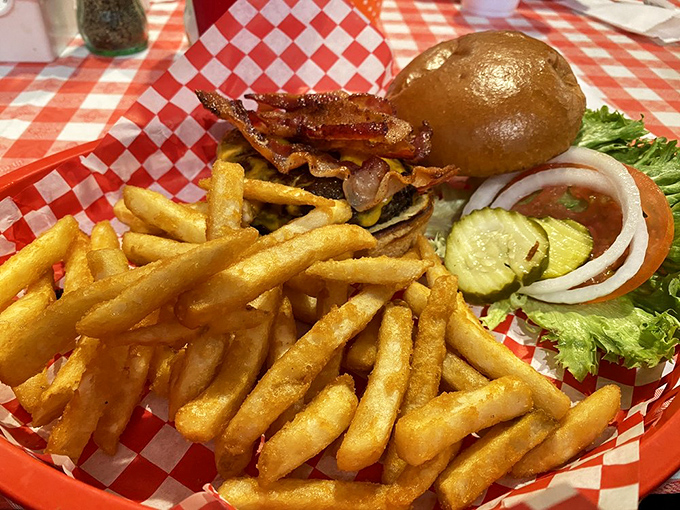 A burger that requires a game plan to eat, served with golden fries that crackle with each bite. This isn't fast food; it's slow-down-and-savor food. 