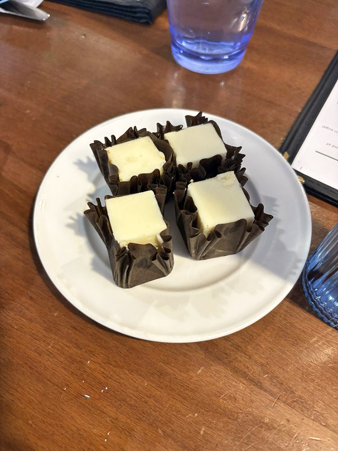 The infamous cheesecake bites arrive like tiny edible gift boxes, their chocolate wrappers barely containing the creamy treasure within.