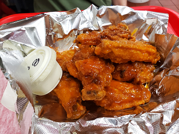 These chicken wings aren't trying to win beauty contests; they're too busy delivering that perfect buffalo sauce kick that makes napkins essential and regrets impossible.