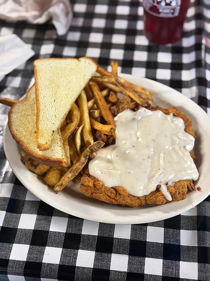 Behold the chicken fried steak in all its gravy-drenched glory. That Texas toast standing guard knows it's witnessing greatness on a plate.