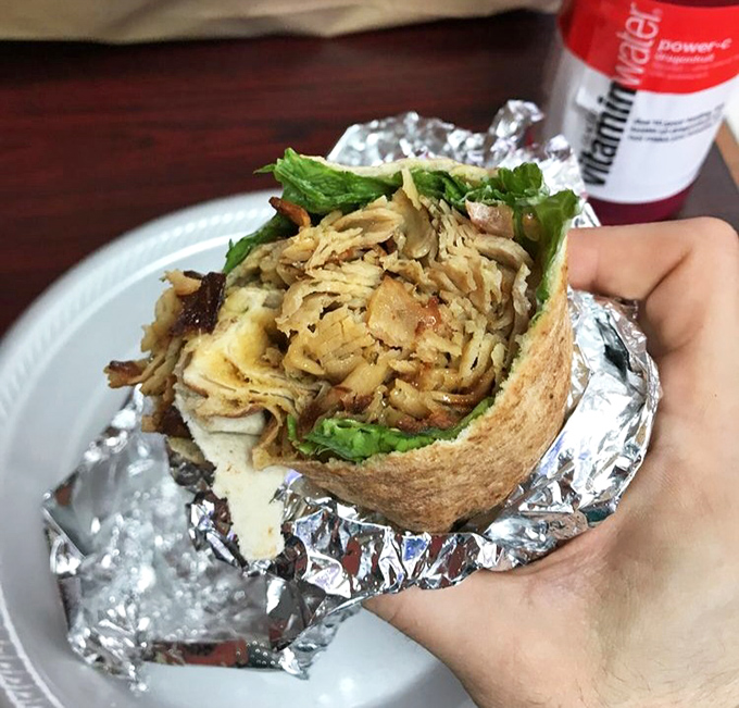 The chicken wrap, expertly assembled and ready for its close-up. Those crisp greens and perfectly seasoned meat are about to make someone's day significantly better. 