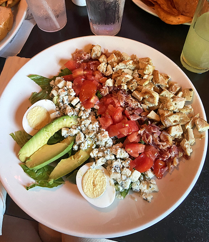 Not just any Cobb salad&mdash;this is a masterpiece of careful arrangement. Avocado, egg, bacon, tomato, and blue cheese creating a symphony of flavors that somehow feels both indulgent and virtuous.