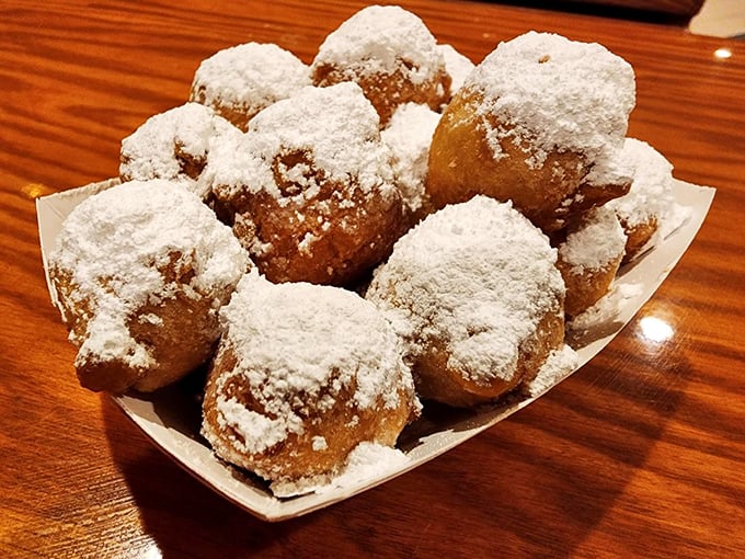 These powdered sugar-dusted corn fritters aren't just a side dish; they're an institution that has launched a thousand "just one more" negotiations at tables across decades.