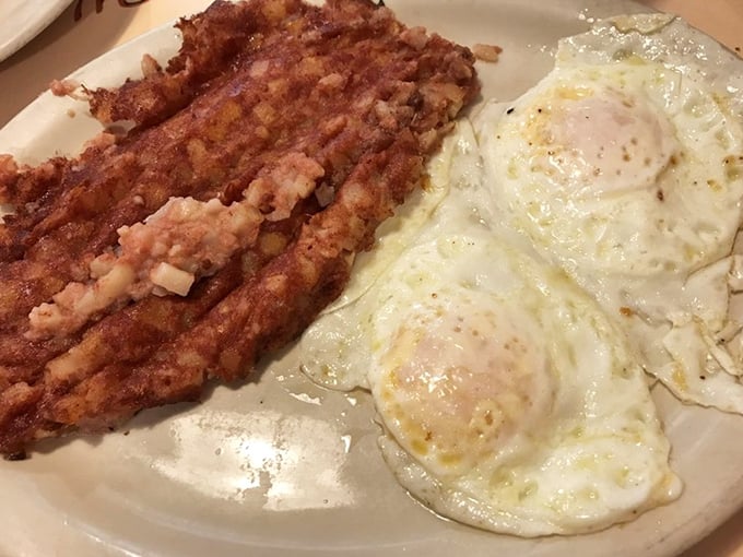 The holy trinity of diner breakfast: perfectly crisped corned beef hash, sunny-side-up eggs with just-right runny yolks, and a plate big enough for proper mixing.
