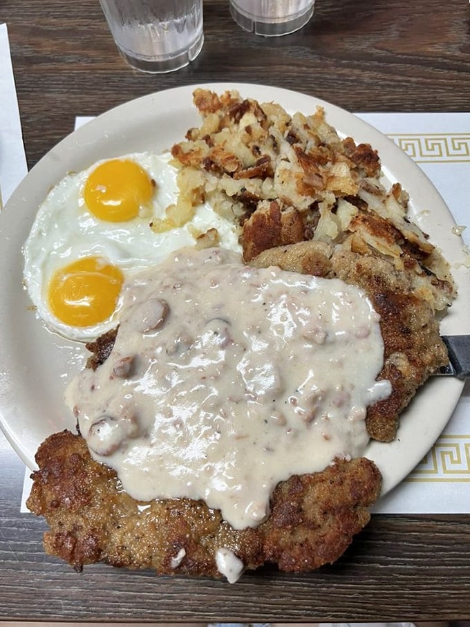 Country fried steak smothered in creamy gravy alongside sunny-side-up eggs. This plate doesn't just feed you&mdash;it hugs you from the inside out.